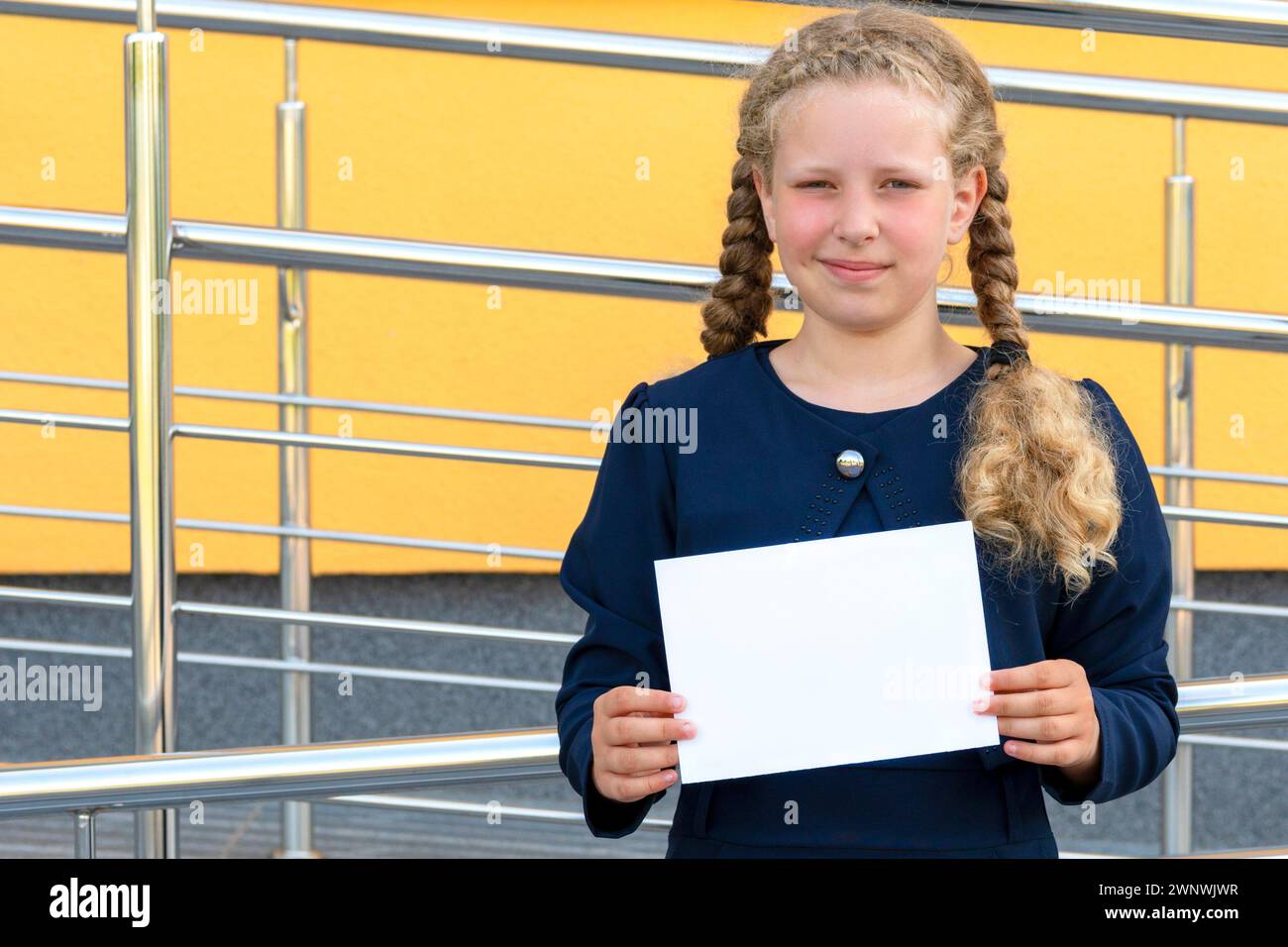 girl holding paper . girl in a uniform. pupil, learner, scholar ...