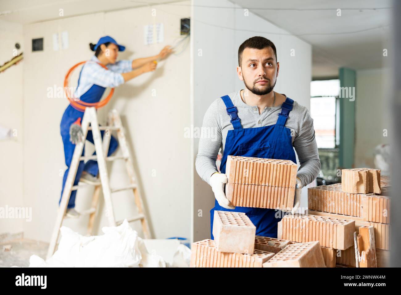 Male builder carrying bricks hi-res stock photography and images - Alamy