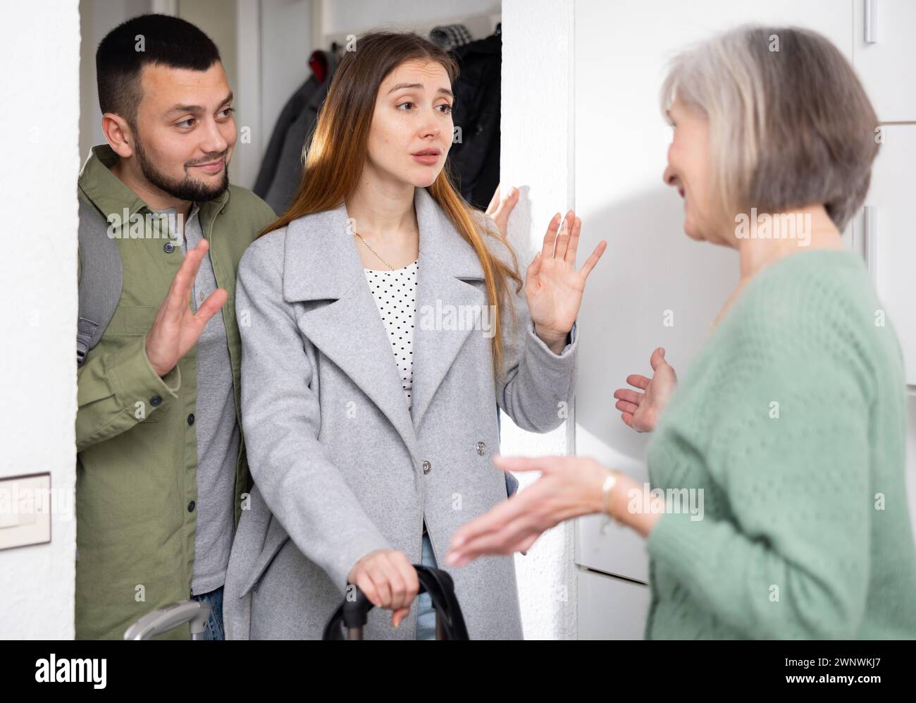 Couple saying goodbye to senior woman Stock Photo - Alamy