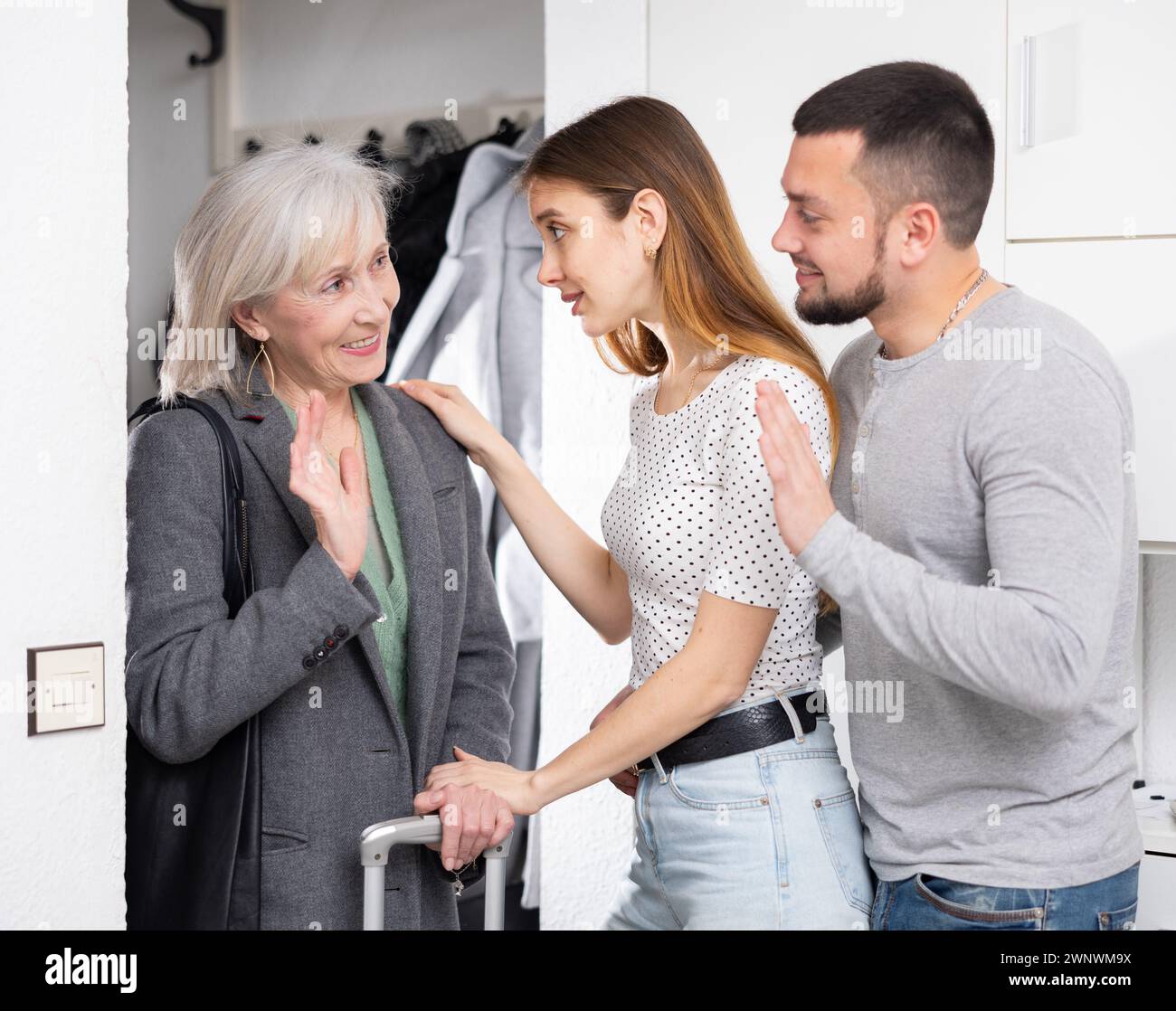 Young family couple seeing off mature woman Stock Photo - Alamy