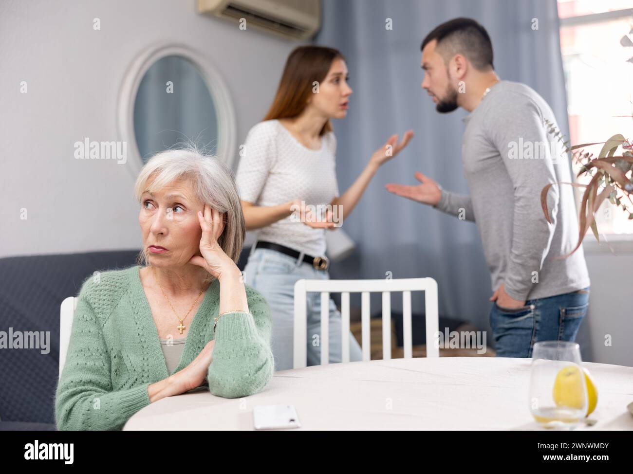 Old woman ignoring her daughter and son-in-law arguing with each other ...