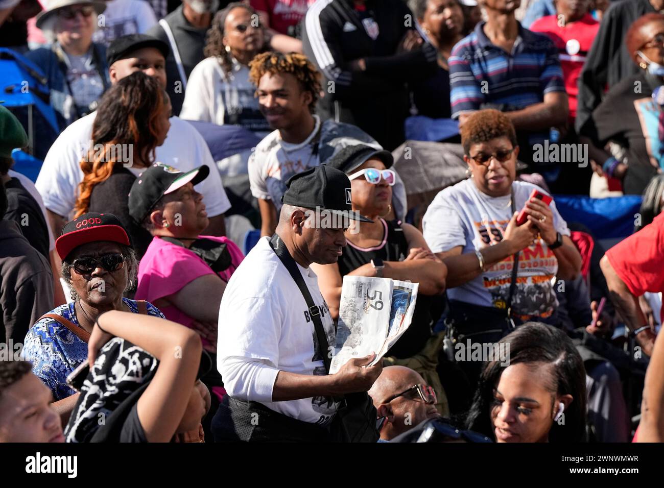 People gather to listen to speakers before walking across the Edmund ...