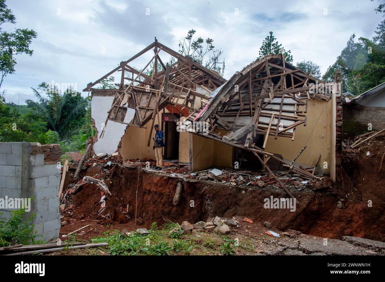 West Java, Indonesia. 4th Mar, 2024. A man stands near damaged ...
