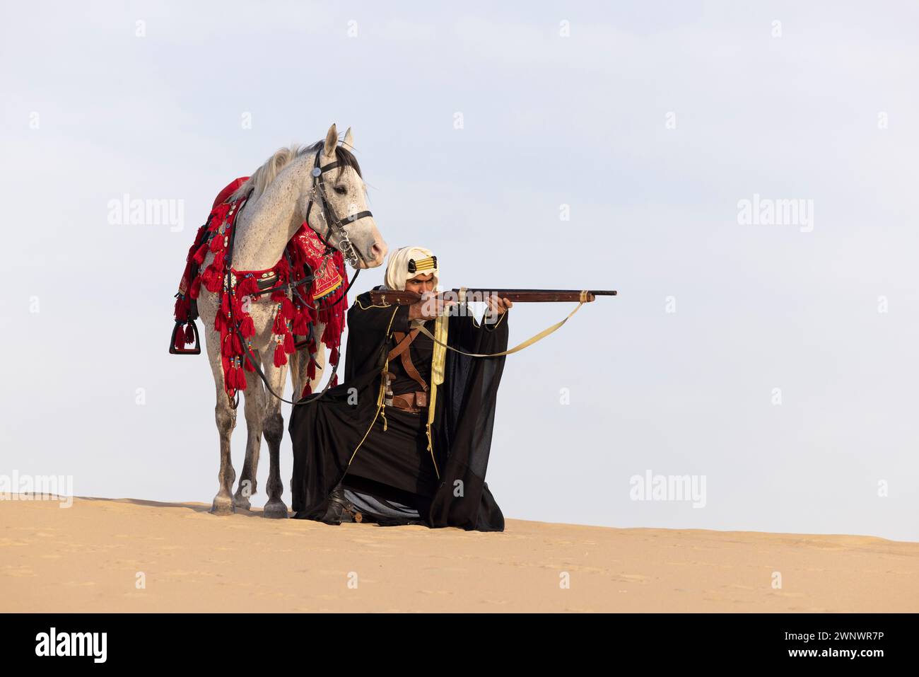 Saudi man hunting in the desert, aiming his rifle Stock Photo - Alamy