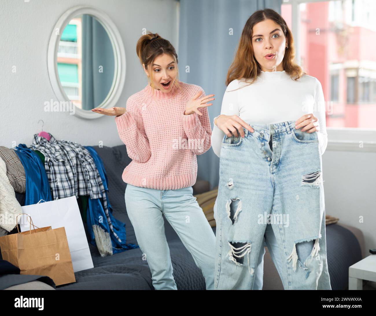Two young women choosing clothes to wear Stock Photo - Alamy