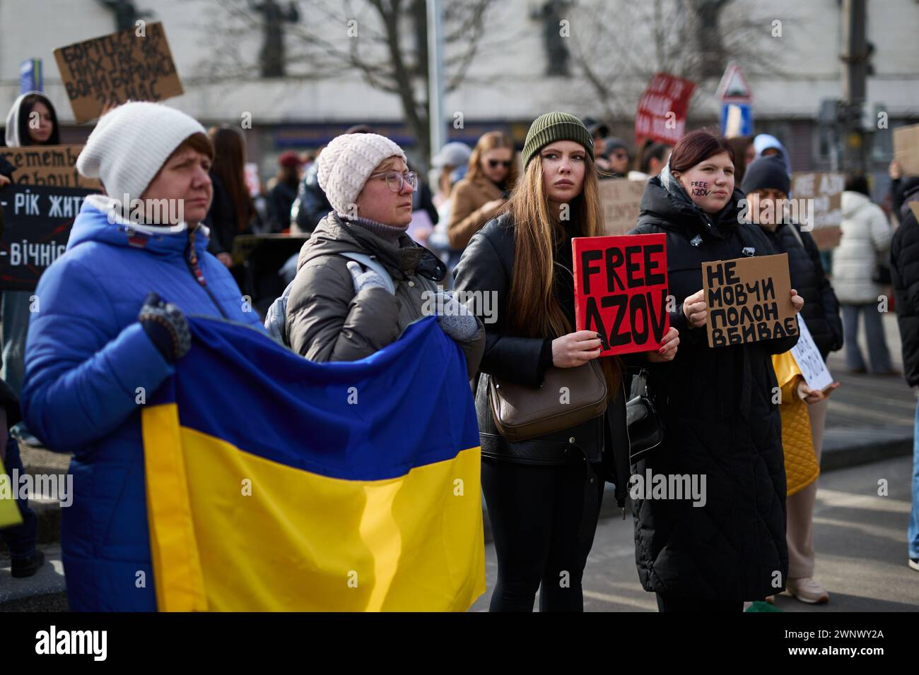 Ukrainian women hold national flag and banners "Free Azov" on a public ...