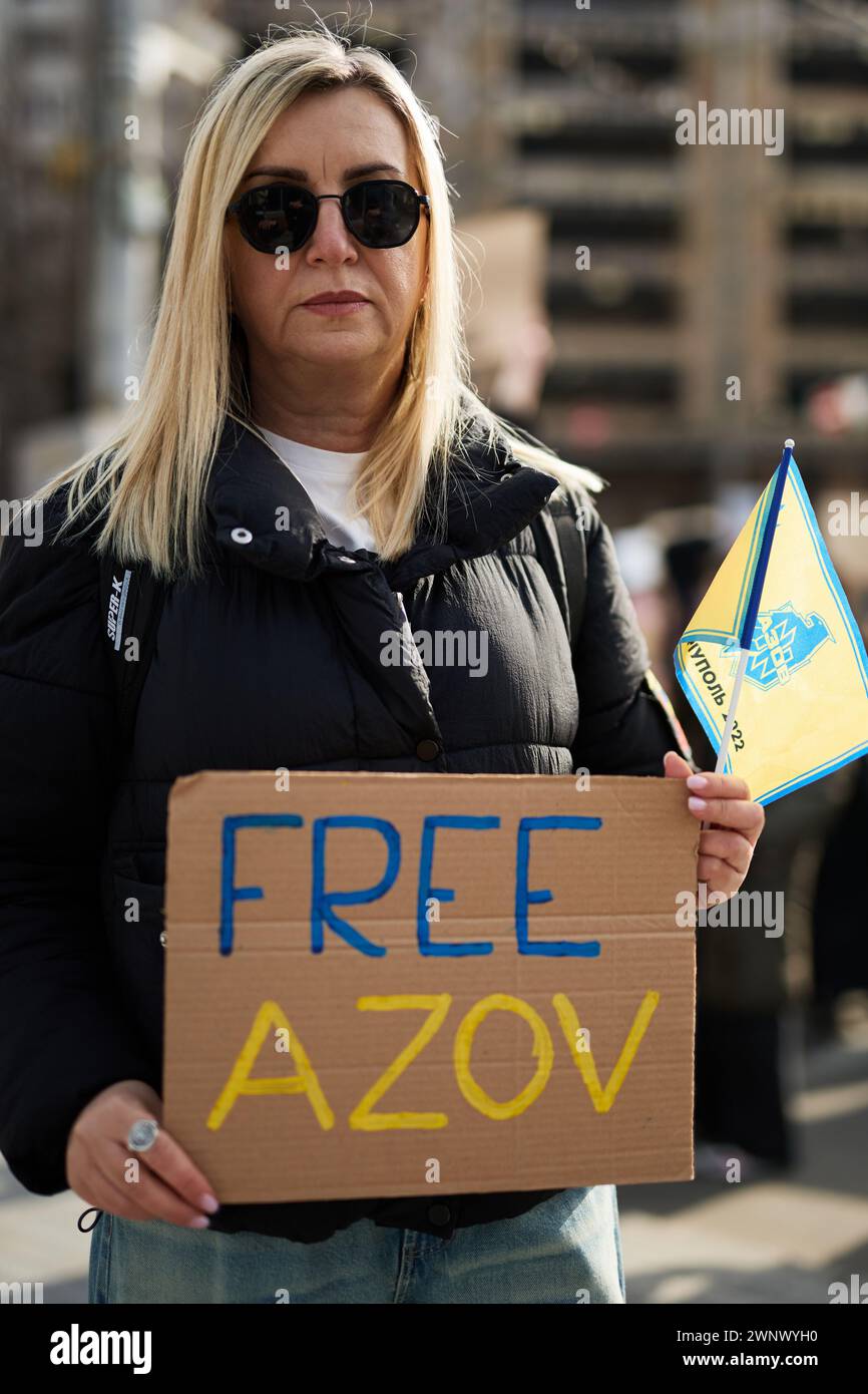 Ukrainian woman showing a banner "Free Azov" on a peaceful rally ...