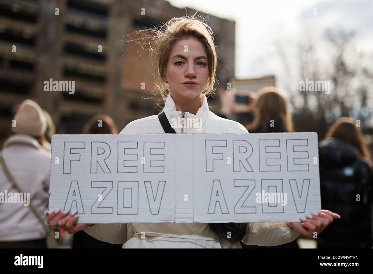 Young Ukrainian female showing a banner "Free Azov" on a public demonstration in Ukraine. Kyiv ...