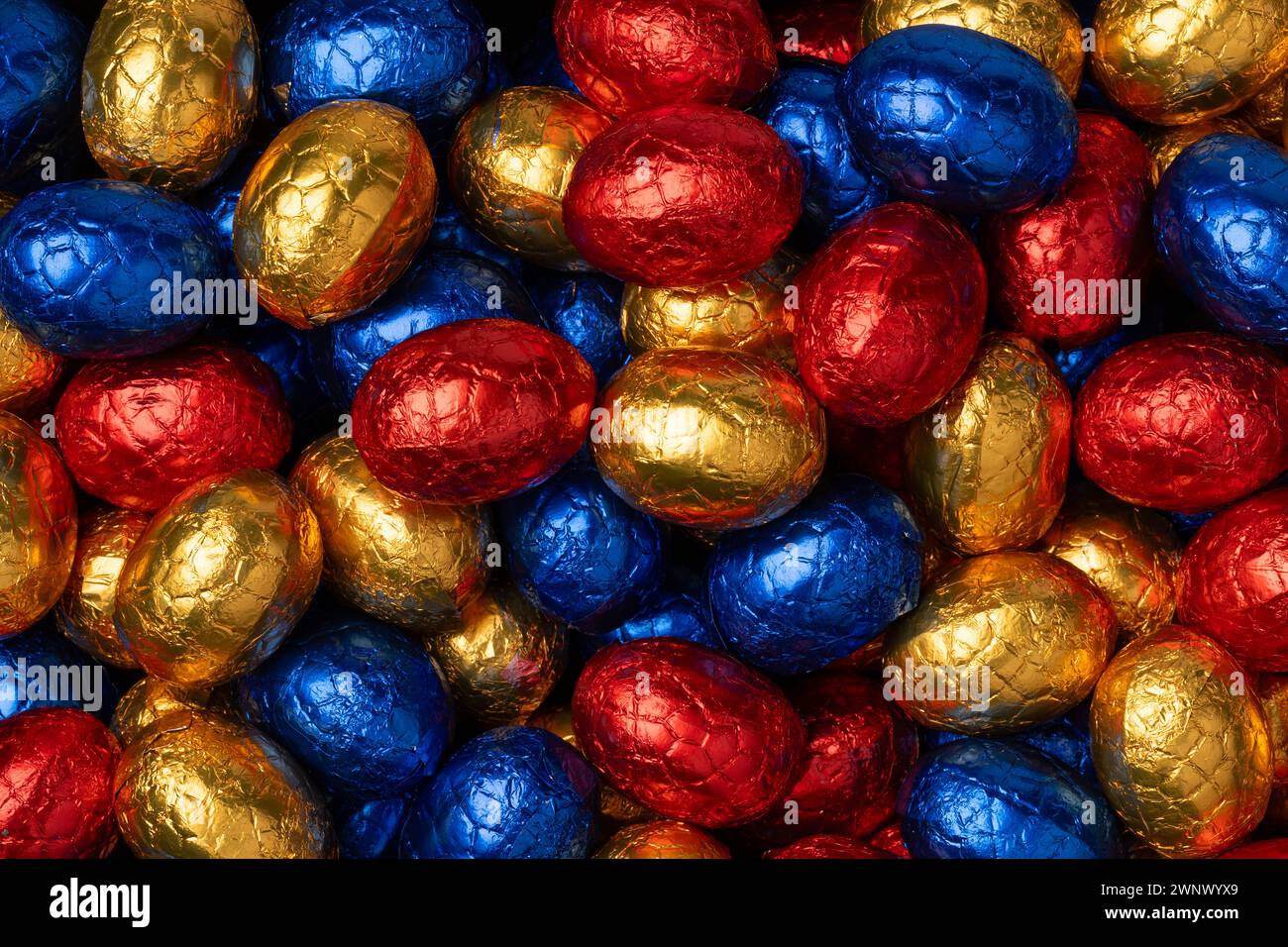 Chocolate easter eggs in colorful tinfoil close up full frame as ...