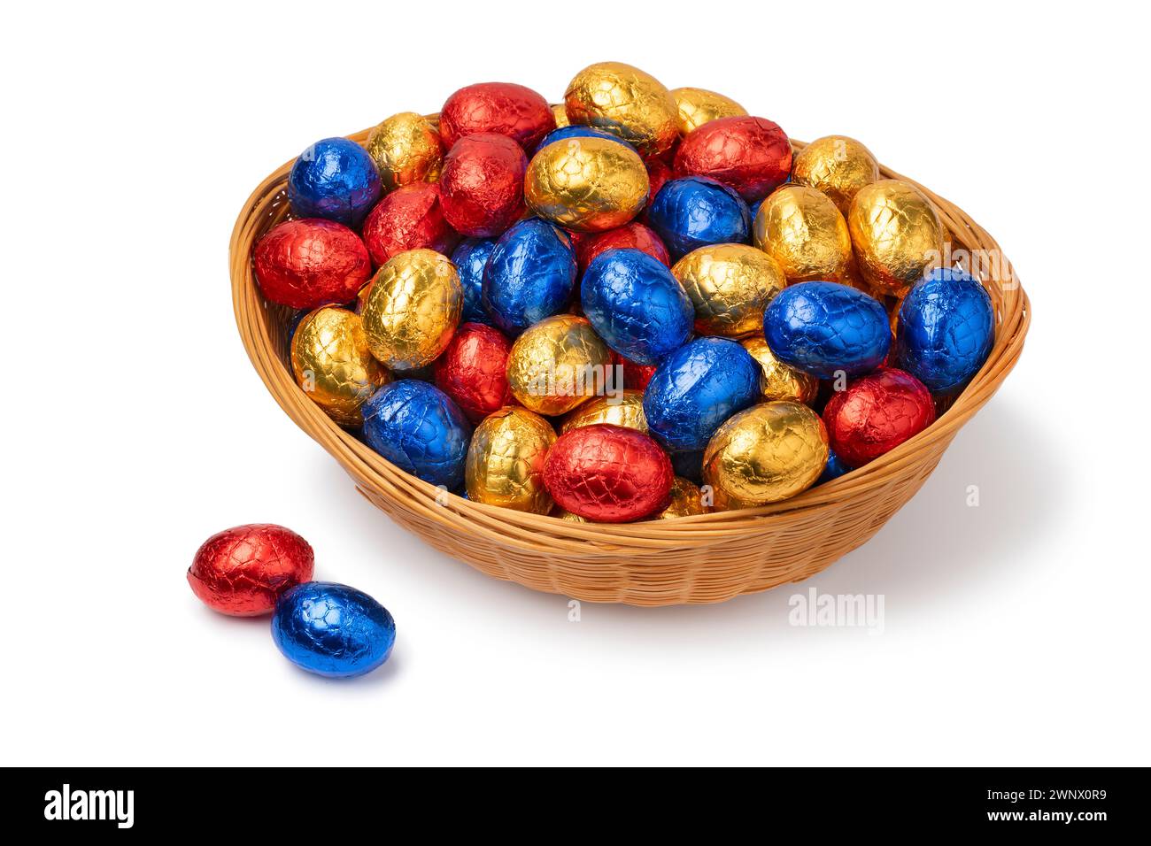 Basket with Chocolate easter eggs in colorful tinfoil close up isolated ...