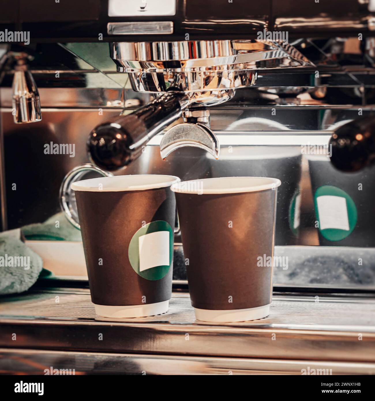 Closeup fresh espresso pouring from a coffee machine into two paper ...
