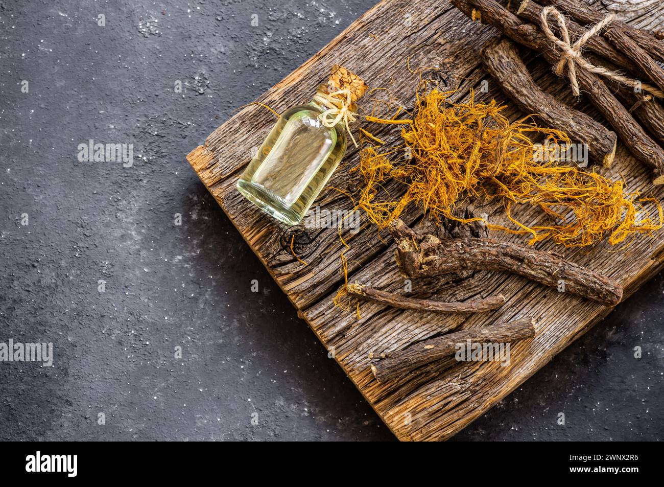 Glass bottle of licorice root essential oil with liquorice fiber on ...