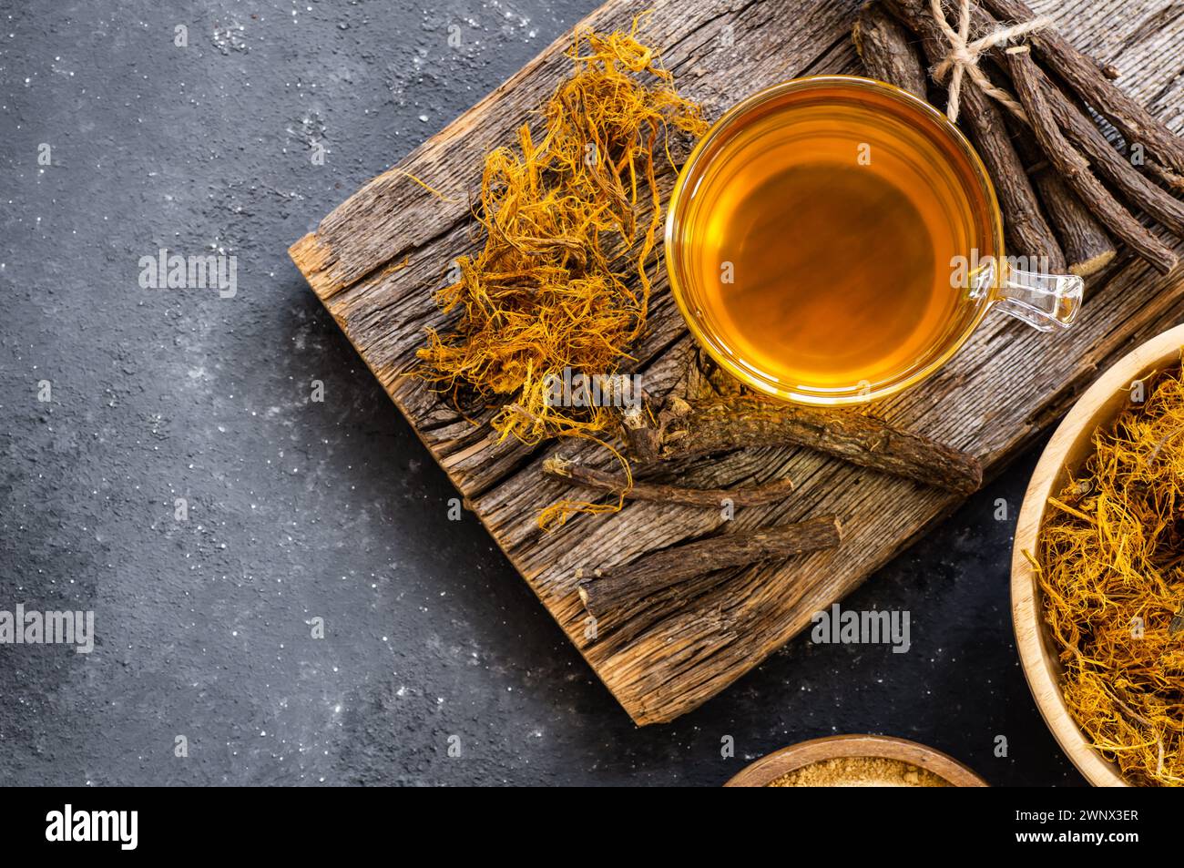 Glass cup of licorice tea with licorice root and fiber on rustic ...