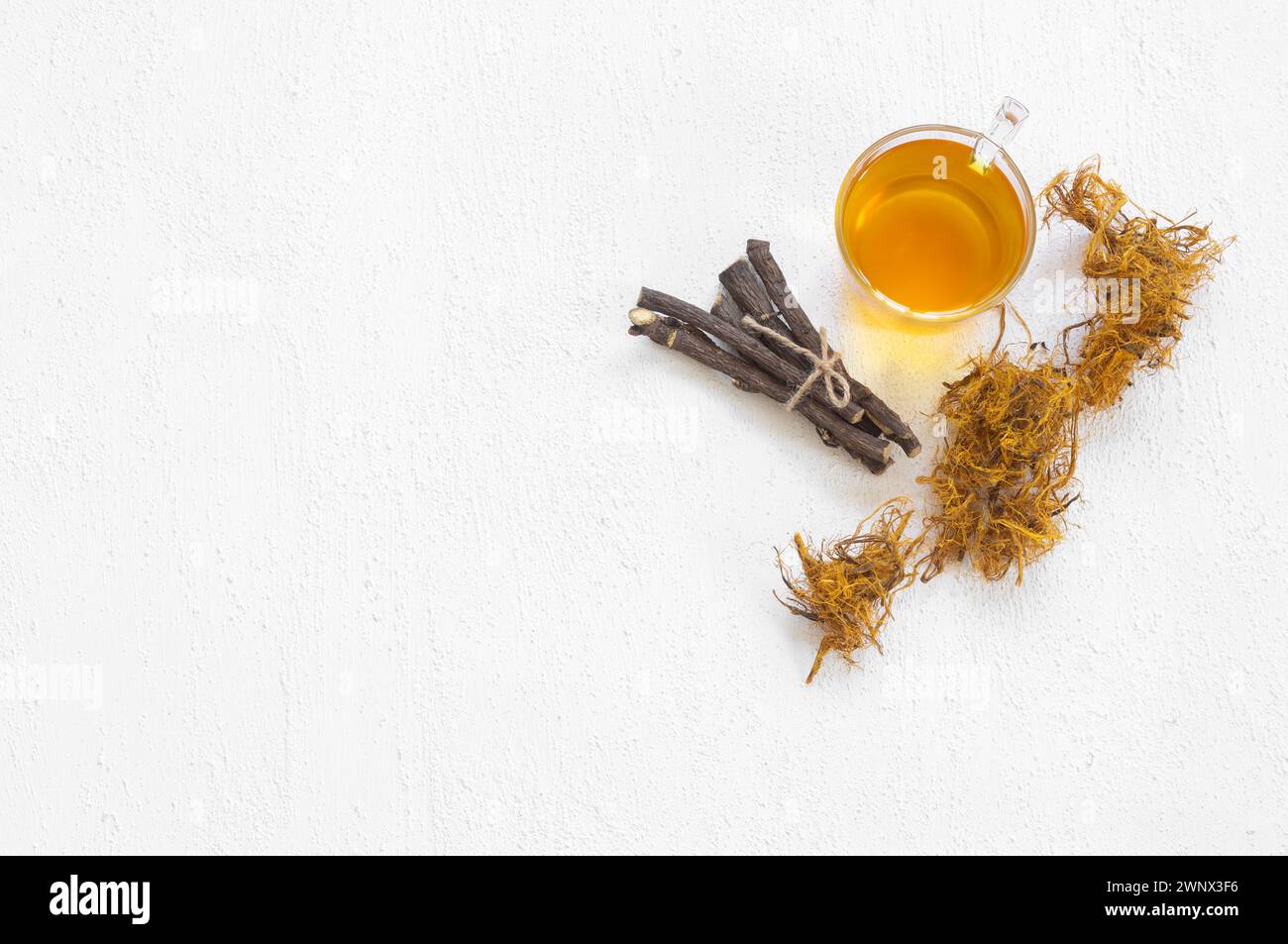 Glass cup of licorice tea with licorice root and fiber on rustic ...