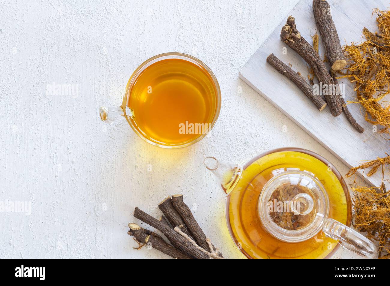Glass cup of licorice tea with licorice root and fiber on rustic ...