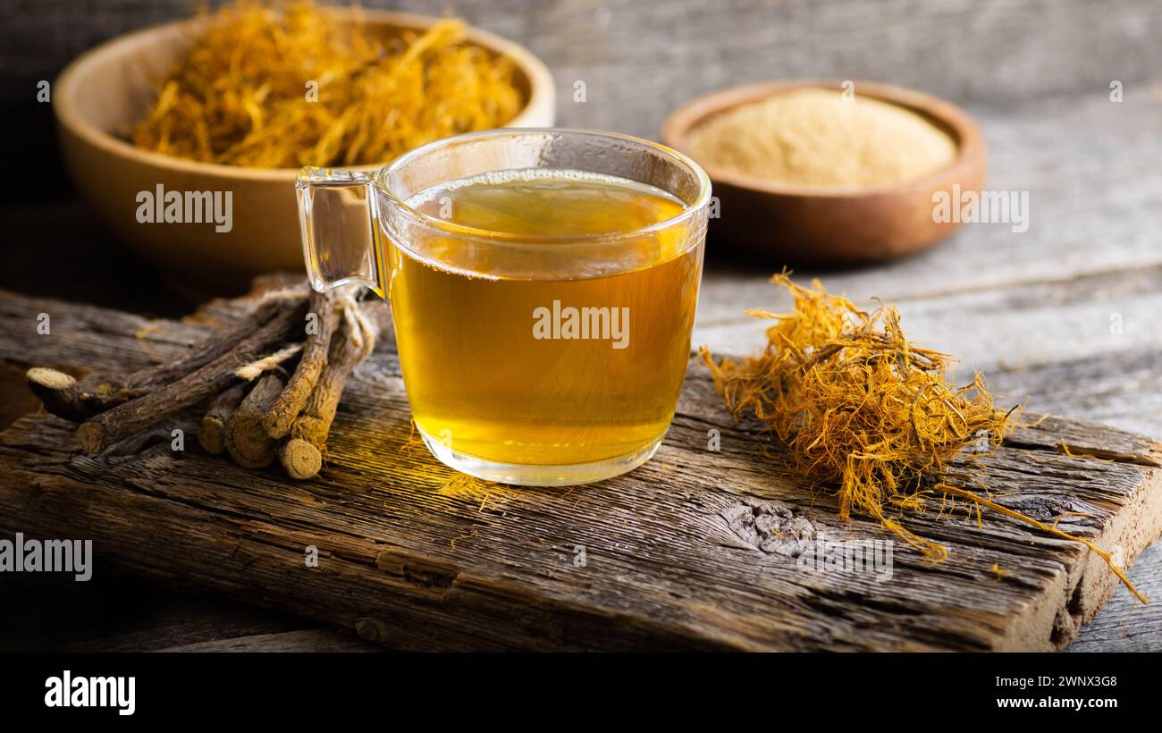 Glass cup of licorice tea with licorice root and fiber on rustic ...