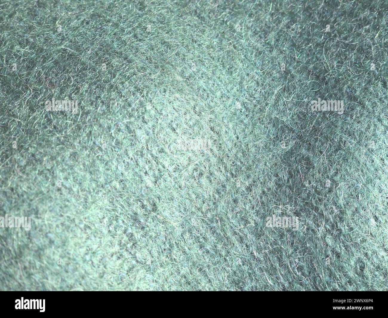 Knitted wool background. Warm winter clothes tied from green yarn brand ...