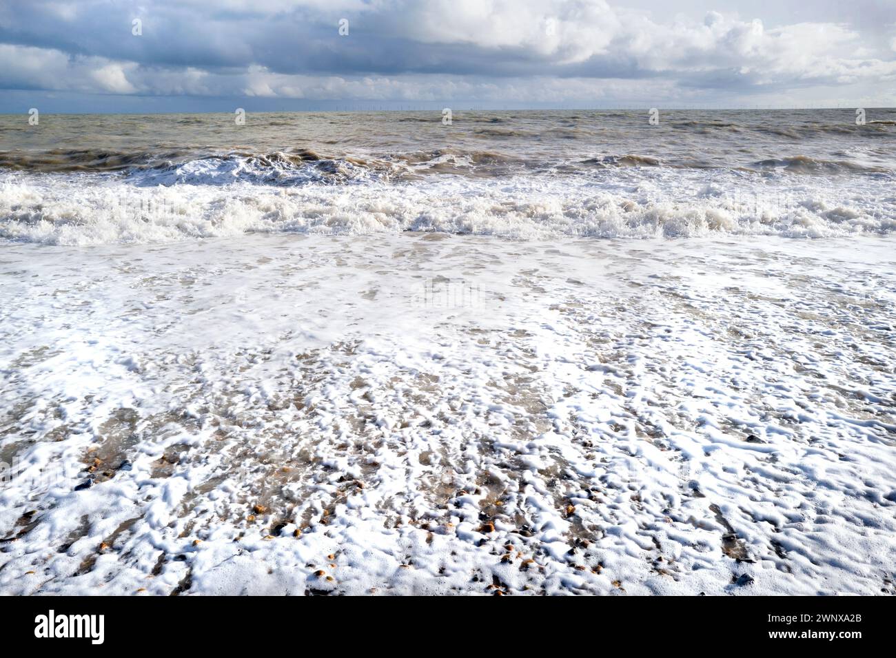 Colour strong sunlight of waves breaking on pebble beach surf, spume ...