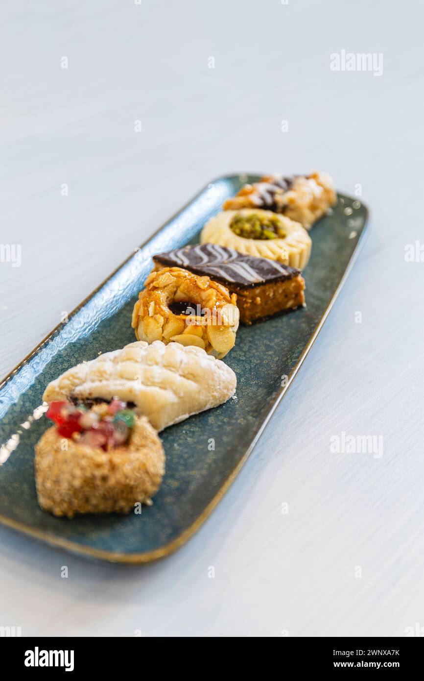 Vertical photo a curated selection of Arabic pastries, each with a ...
