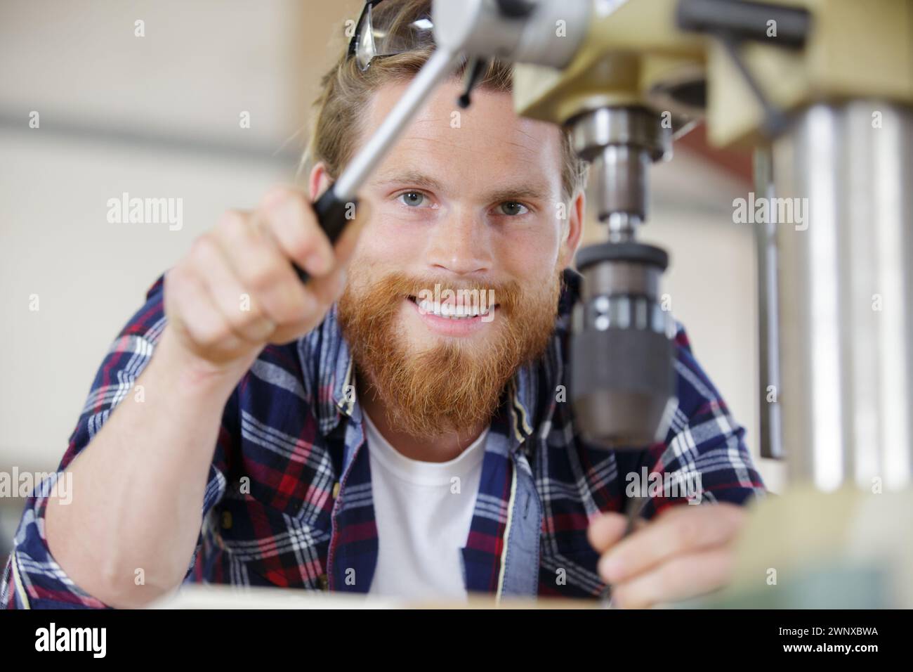a happy man using a wood milling machine Stock Photo - Alamy