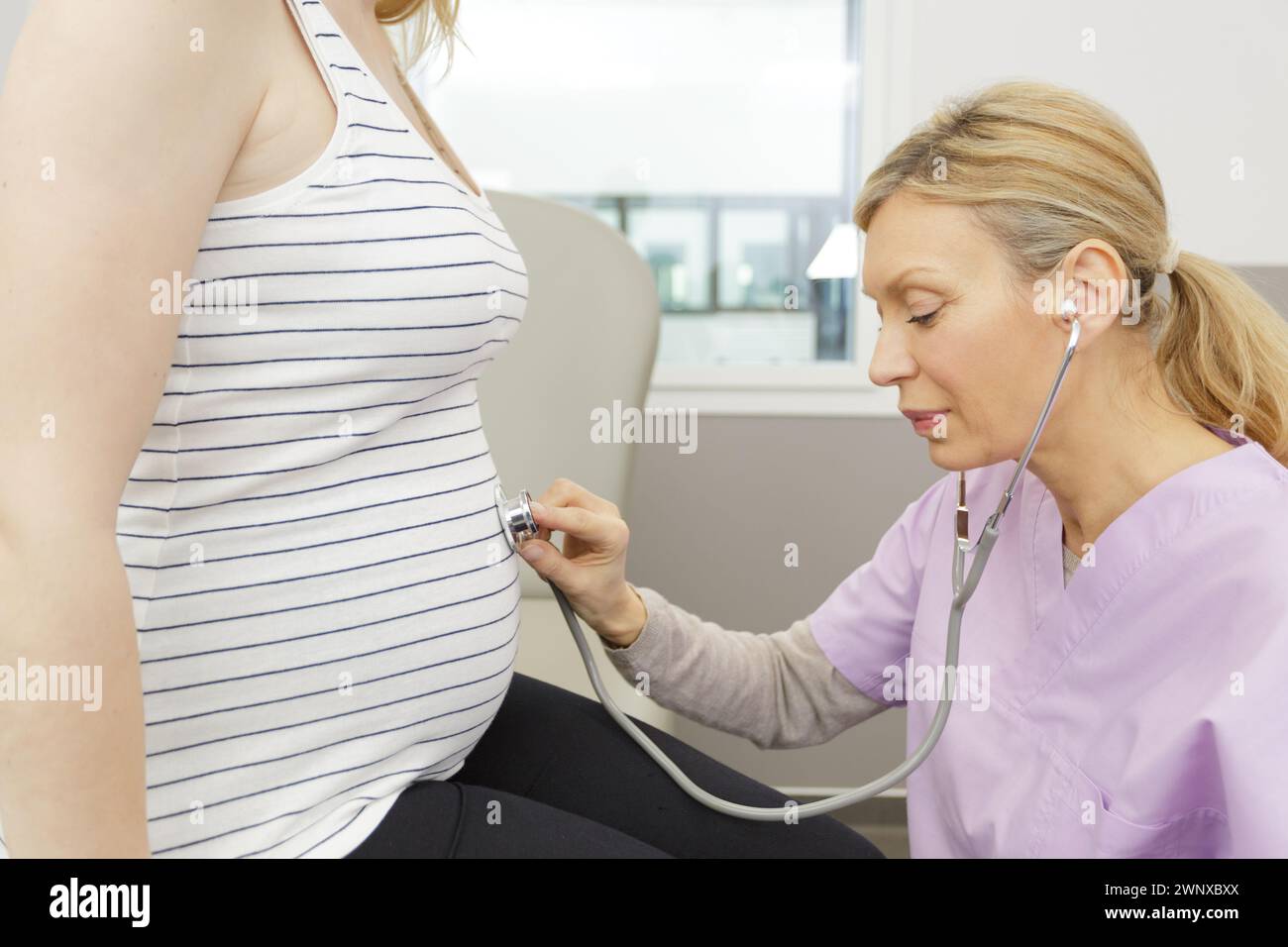 female doctor listens pregnant belly Stock Photo - Alamy