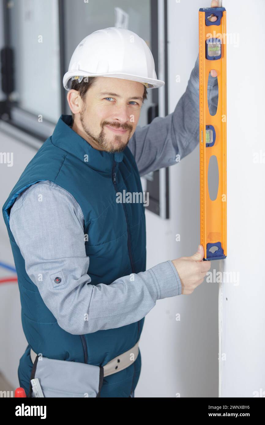 builder using a spirit level at work Stock Photo - Alamy
