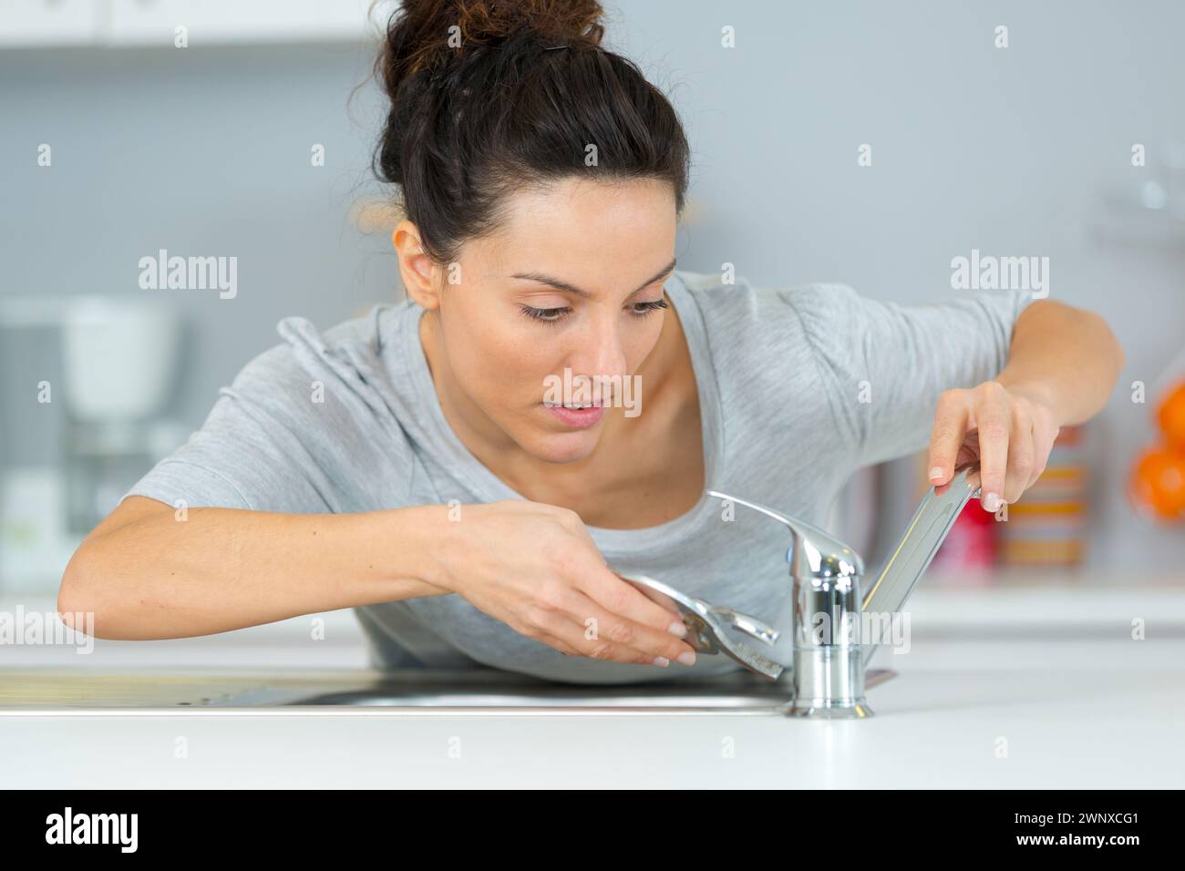 woman fixing kitchen tap Stock Photo - Alamy