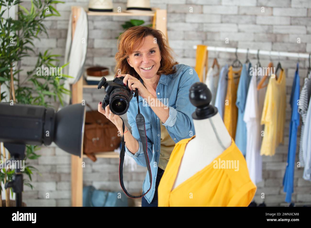 female photographer photographing dress on a mannequin Stock Photo - Alamy