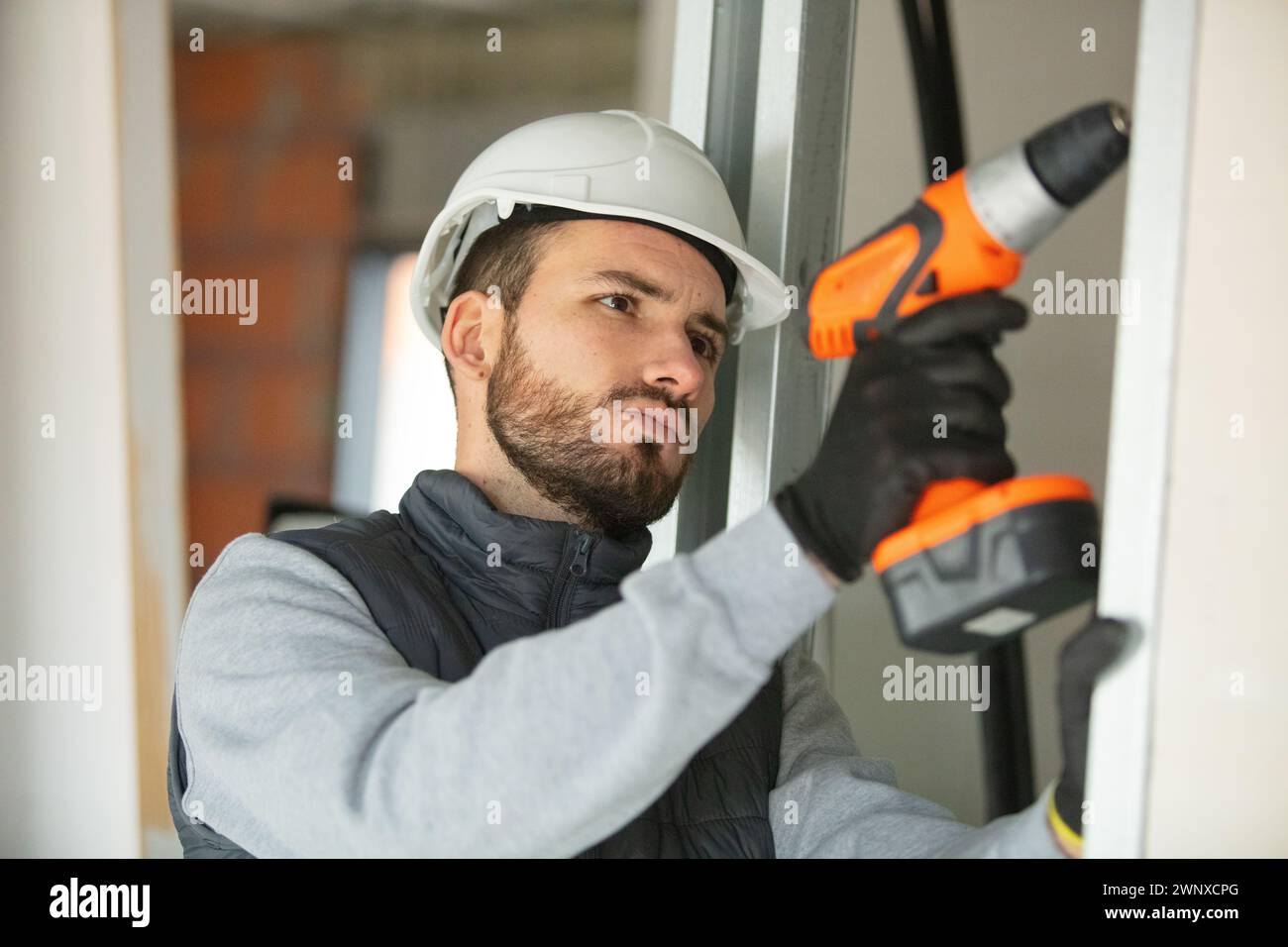 serious young builder using cordless drill Stock Photo - Alamy