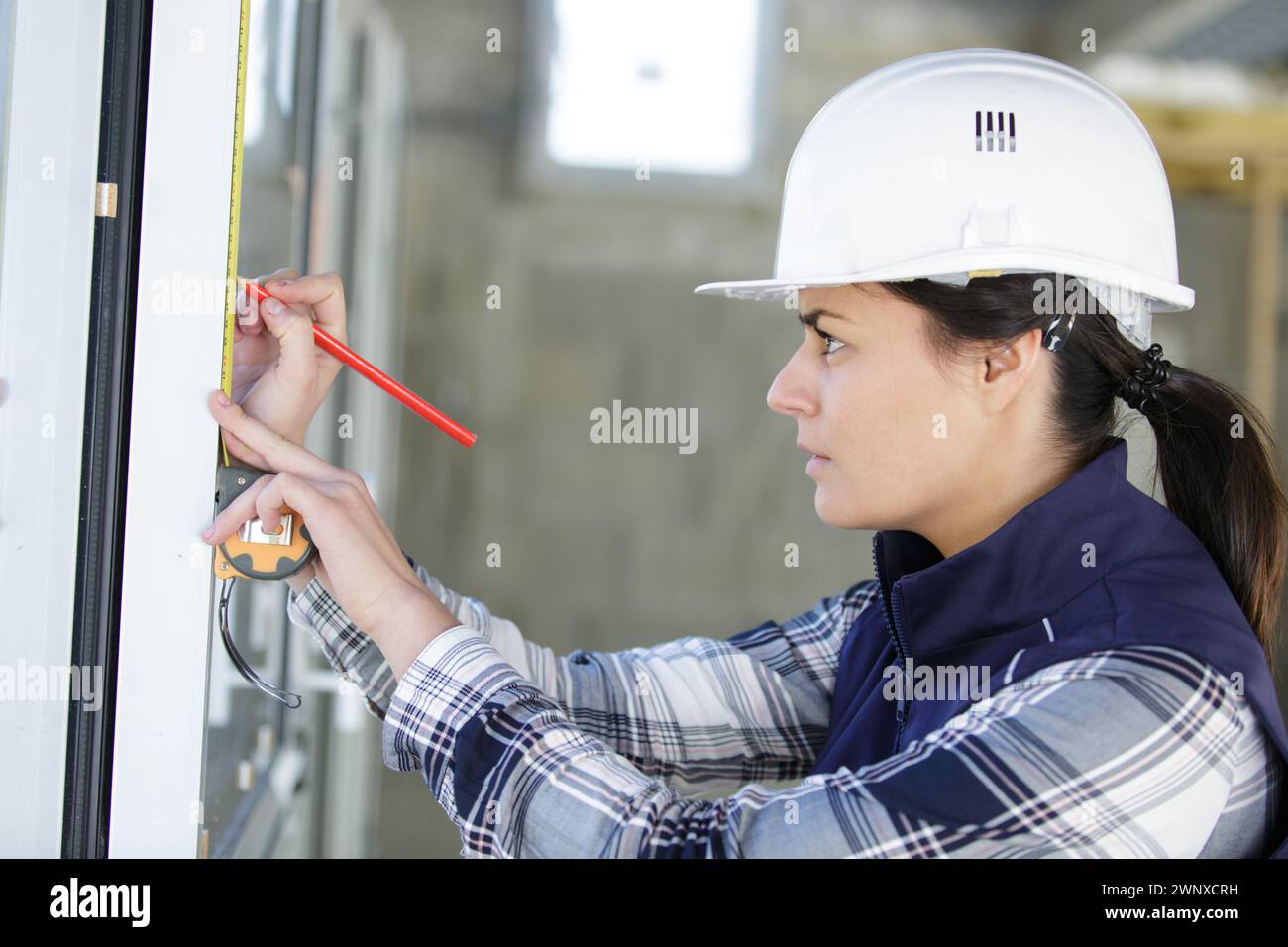 a woman measuring window frame Stock Photo - Alamy