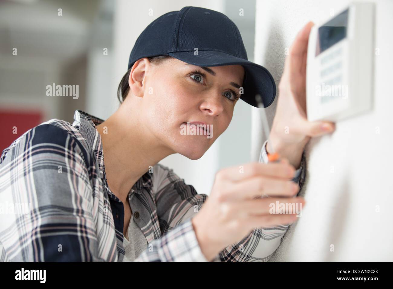 female technician installing security system on the wall Stock Photo ...