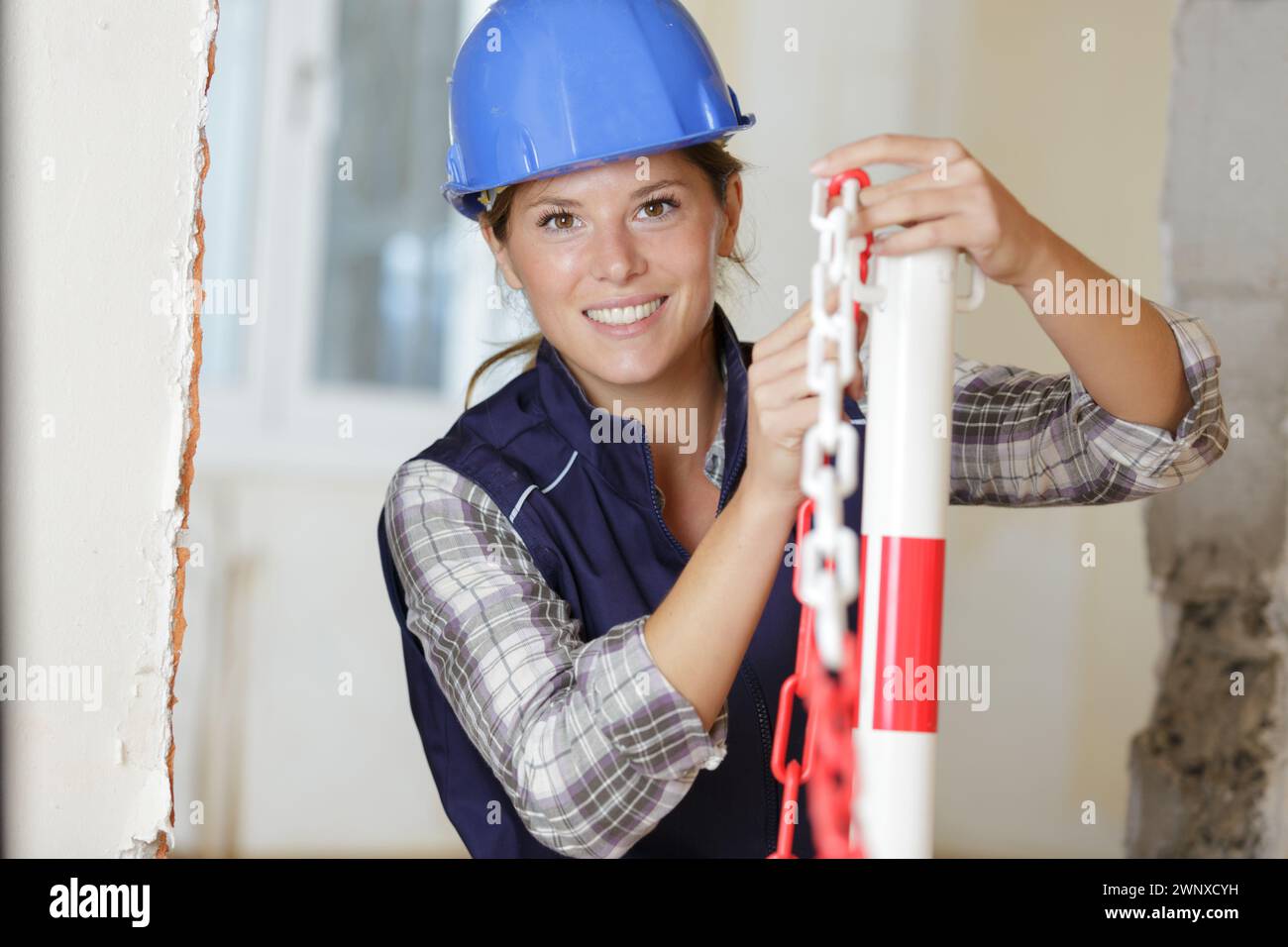 worker putting up exclusion chain on construction site Stock Photo - Alamy