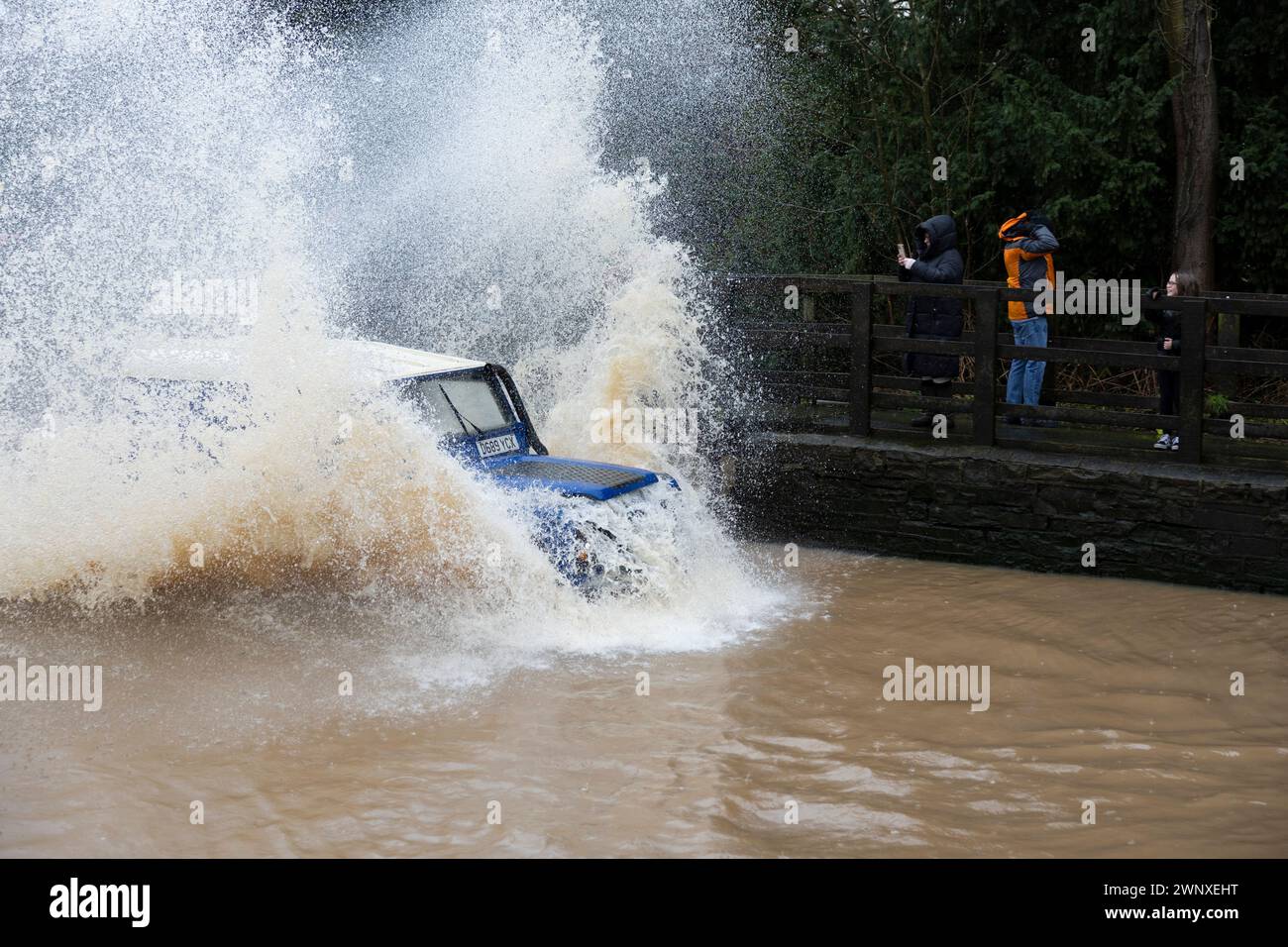 20/02/22 Land Rover Defender splashes young spectators. As heavy rain ...
