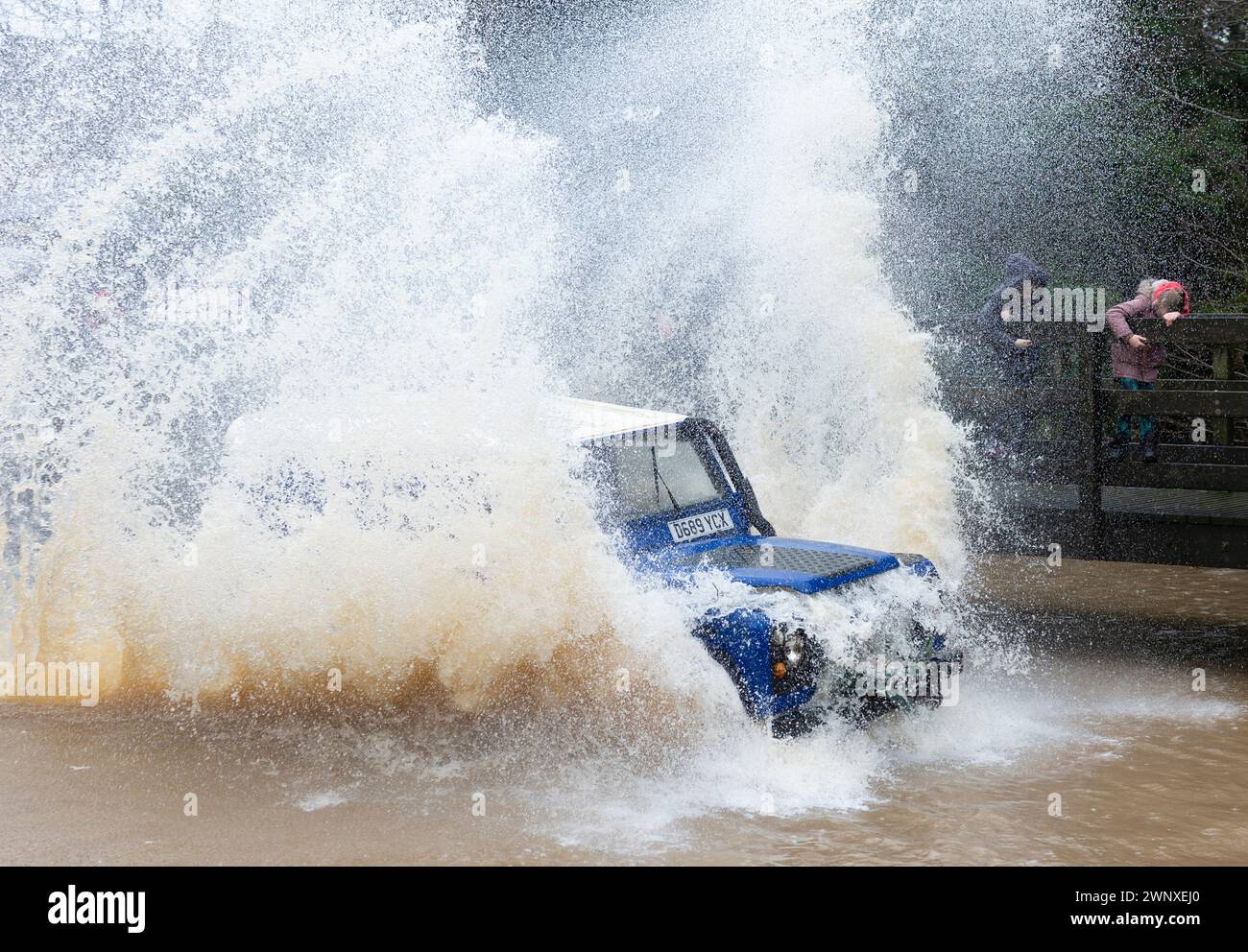 20/02/22 Land Rover Defender splashes young spectators. As heavy rain ...