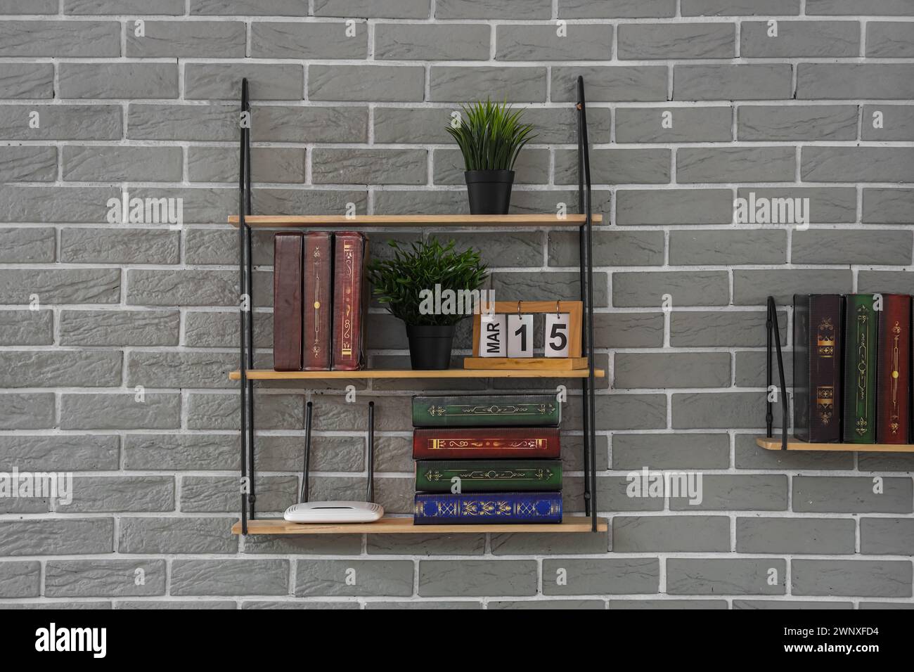 Bookshelf with modern wi-fi router and plants on grey brick wall Stock ...