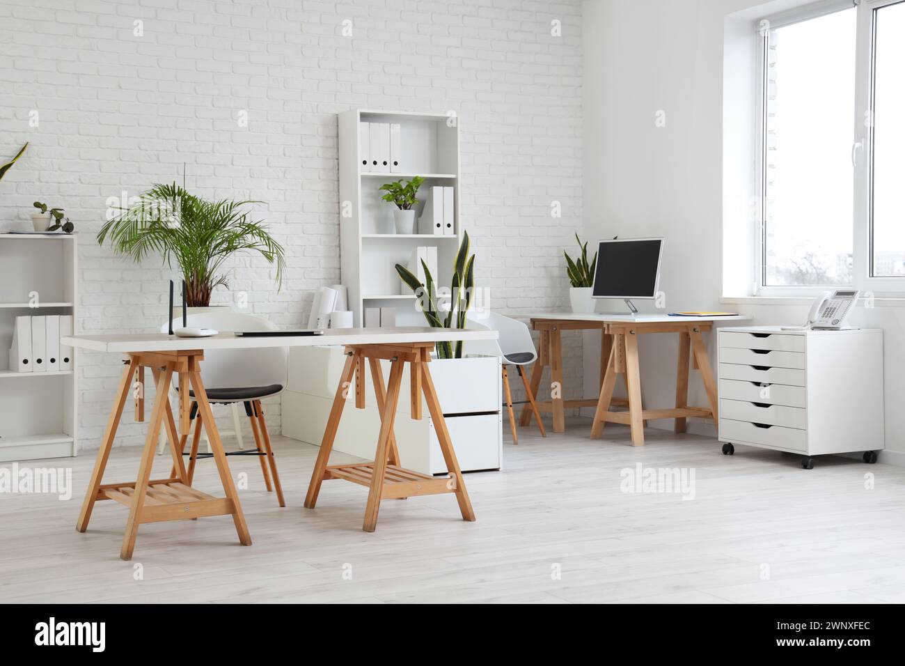 Interior of office with tables and shelf units Stock Photo - Alamy