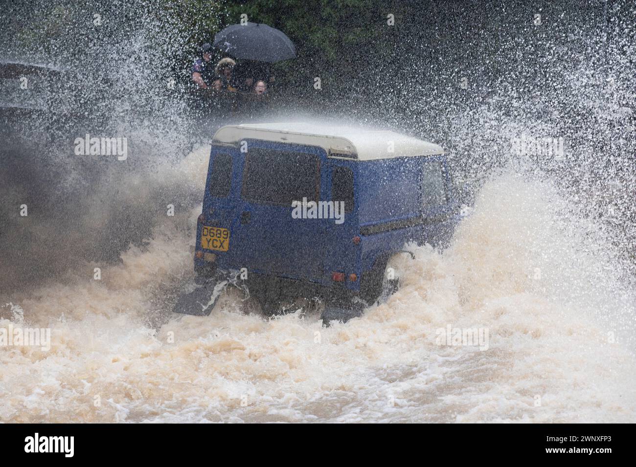 20/02/22 Land Rover Defender splashes young spectators. As heavy rain ...