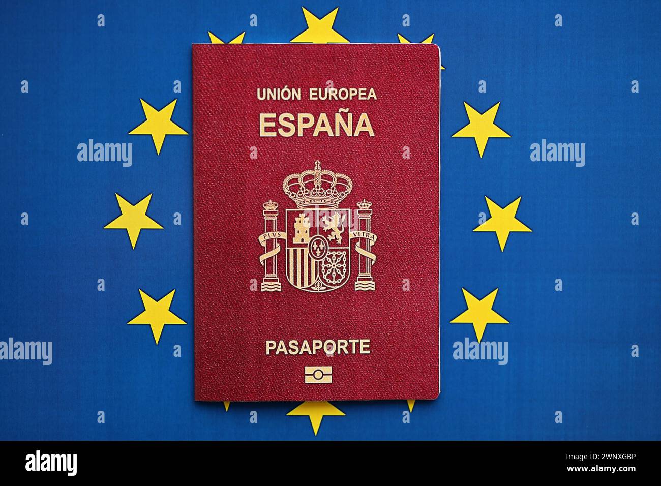 Red Spanish passport of European Union on blue flag background close up ...