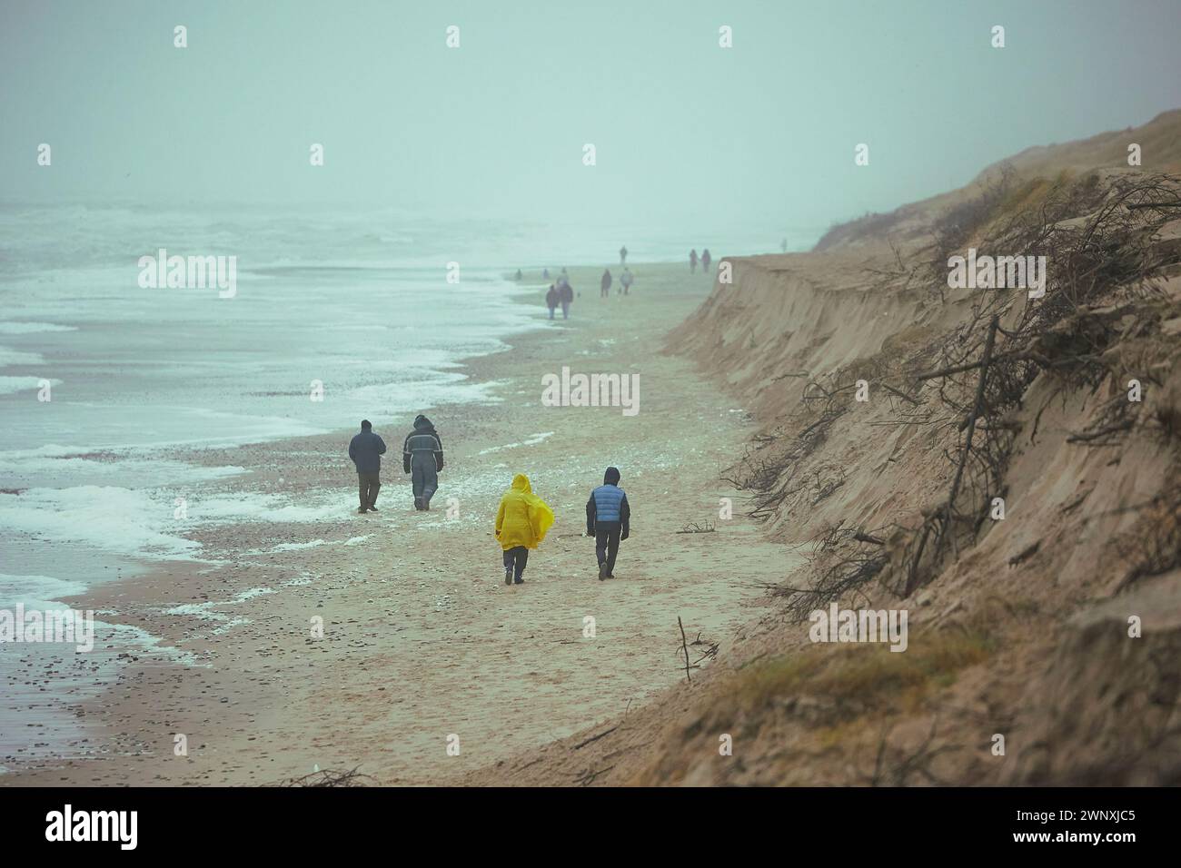 People walk on the beach in stormy weather in Sondervig Denmark Stock ...