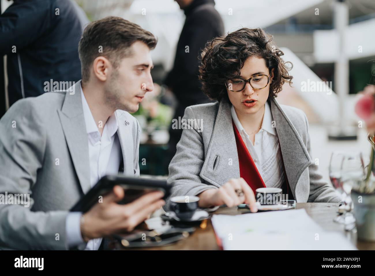 Business partners in discussion at an outdoor cafe setting Stock Photo ...