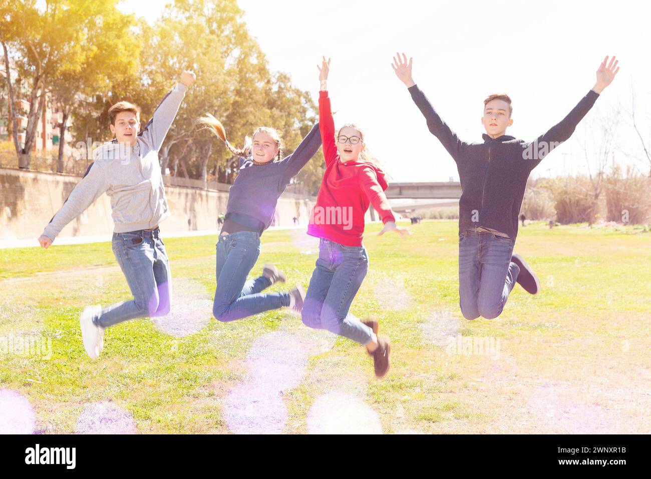 Happy teenagers jumping on the green lawn Stock Photo - Alamy