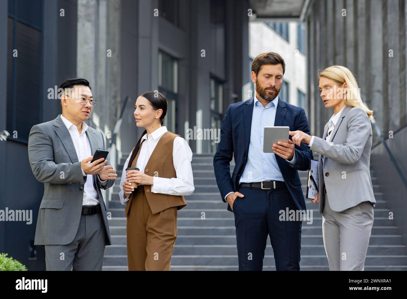 A group of four professionals engaging in a discussion outside a ...