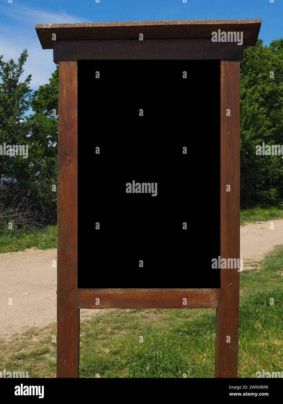 Blank black vertical rectangular pylon stand on forest dirt road mock ...