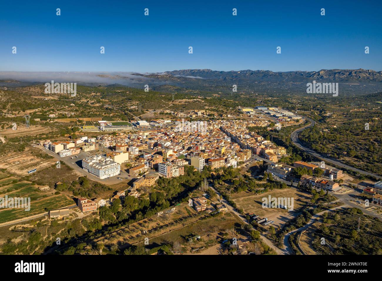 Aerial view of the town of El Perelló on a winter morning with fog over ...