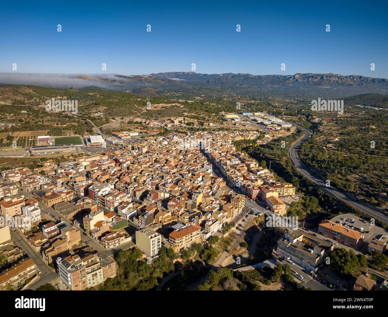 Aerial view of the town of El Perelló on a winter morning with fog over ...