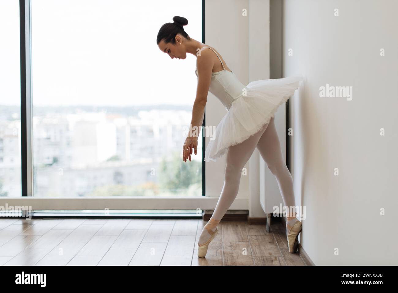 Beautiful graceful ballerina in white practice ballet plie positions ...