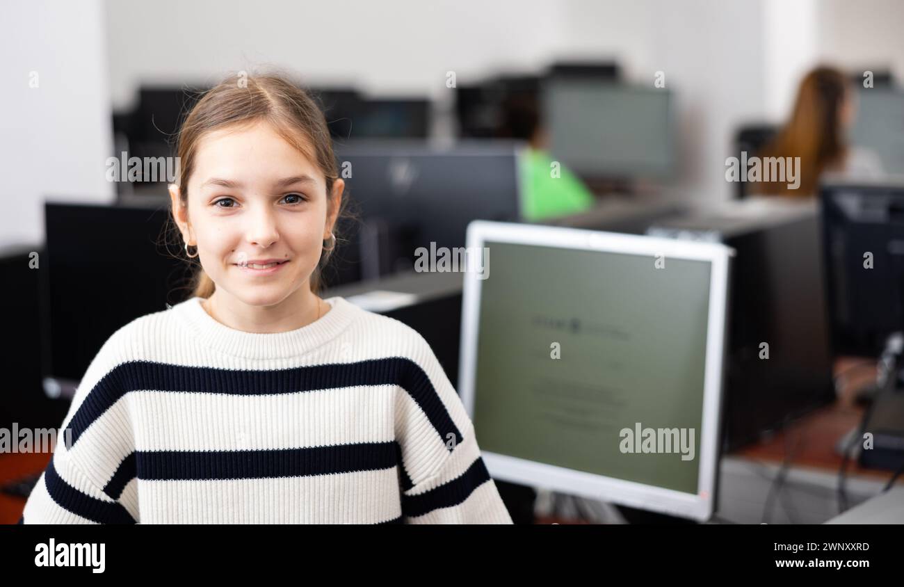 Interested teenage girl student standing in information technology ...