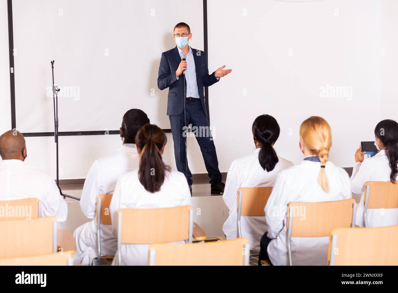 Male coach giving speech at conference hall Stock Photo - Alamy
