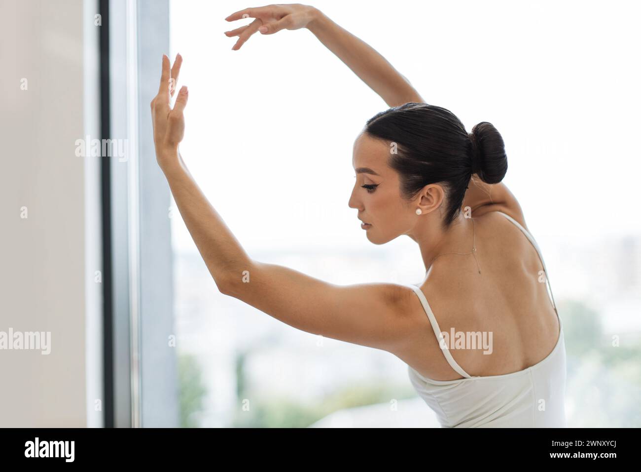 Female ballet dancer makes pirouette at ballet studio in front of big ...