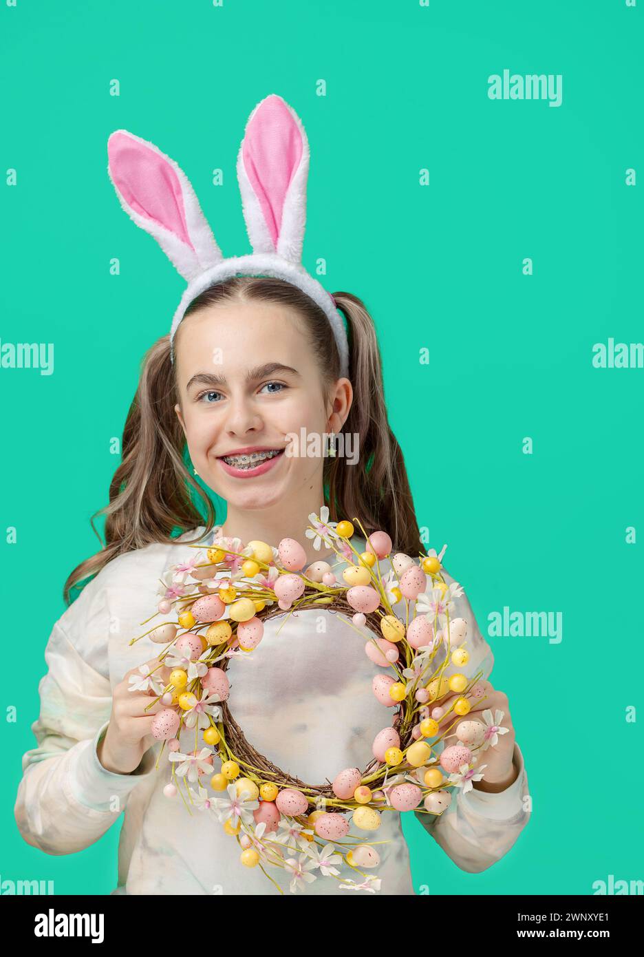 Happy Easter. Girl with joyful smile, in shiny pink rabbit ears and ...
